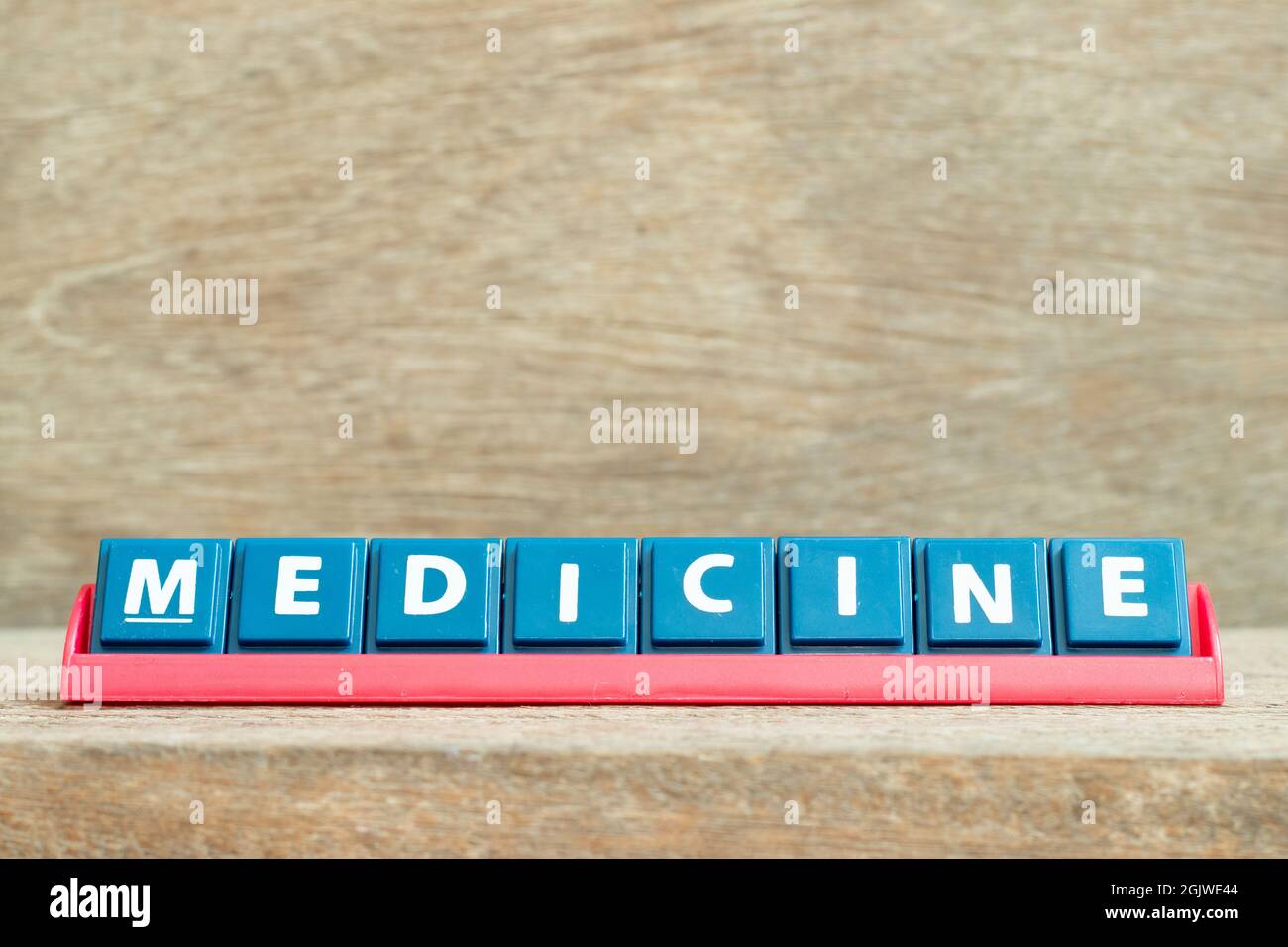 Tile alphabet letter with word medicine in red color rack on wood ...