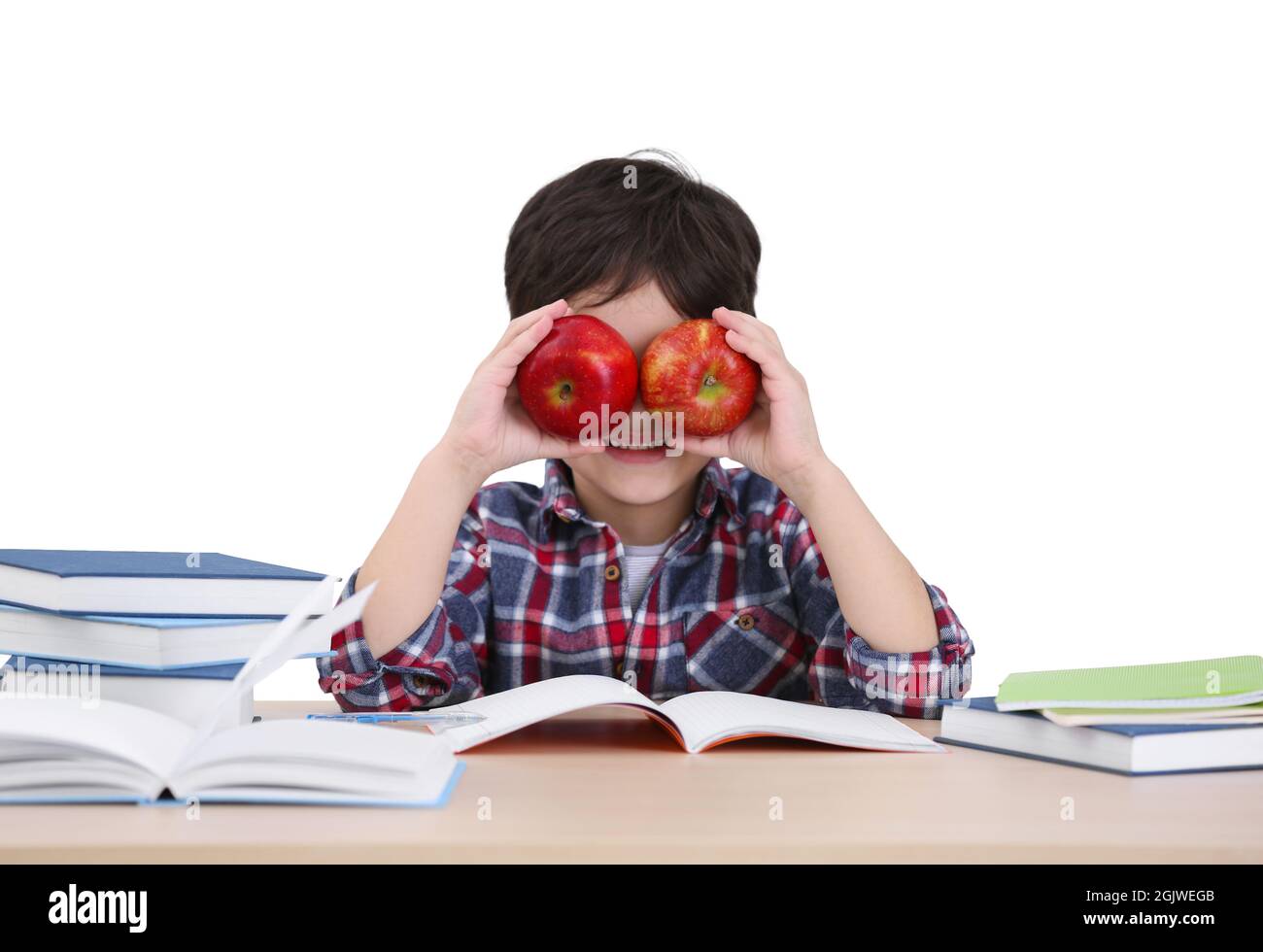 Cute little boy with apples sitting at table, on white background Stock ...