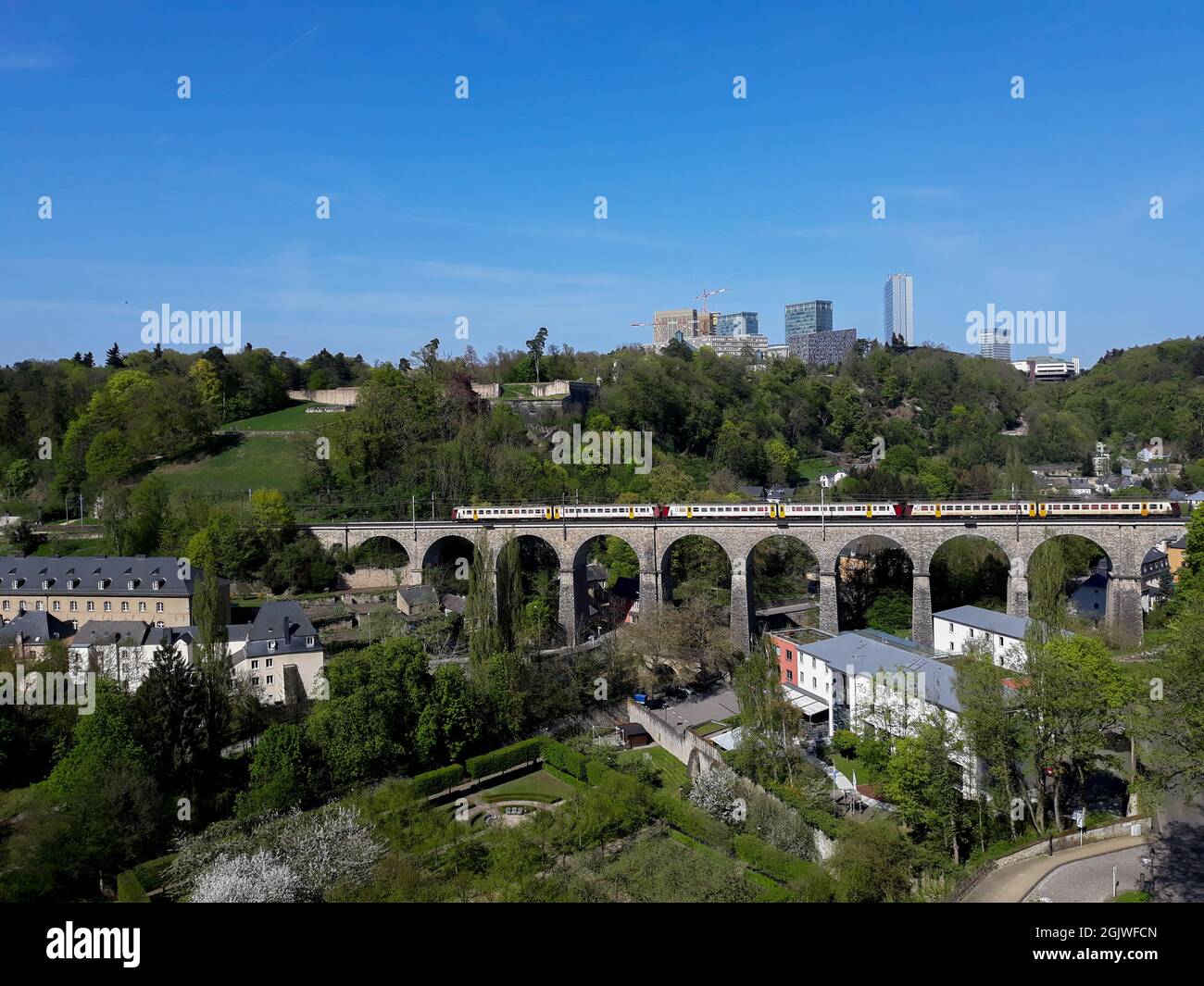 train entering a city by a viaduct Stock Photo - Alamy