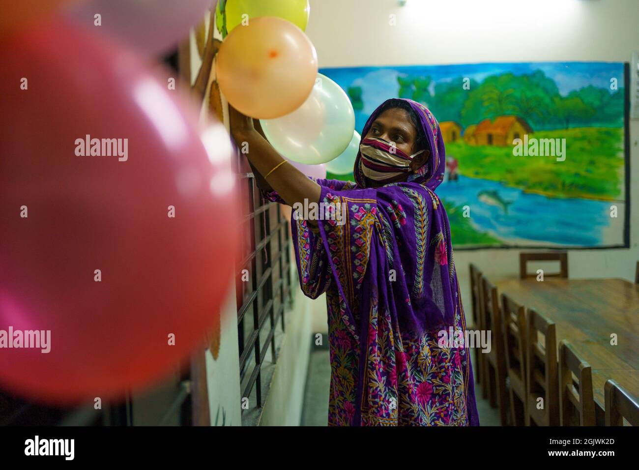 Non Exclusive: DHAKA, BANGLADESH - SEPTEMBER 11: A woman is seen hanging a set of ballons in the ...
