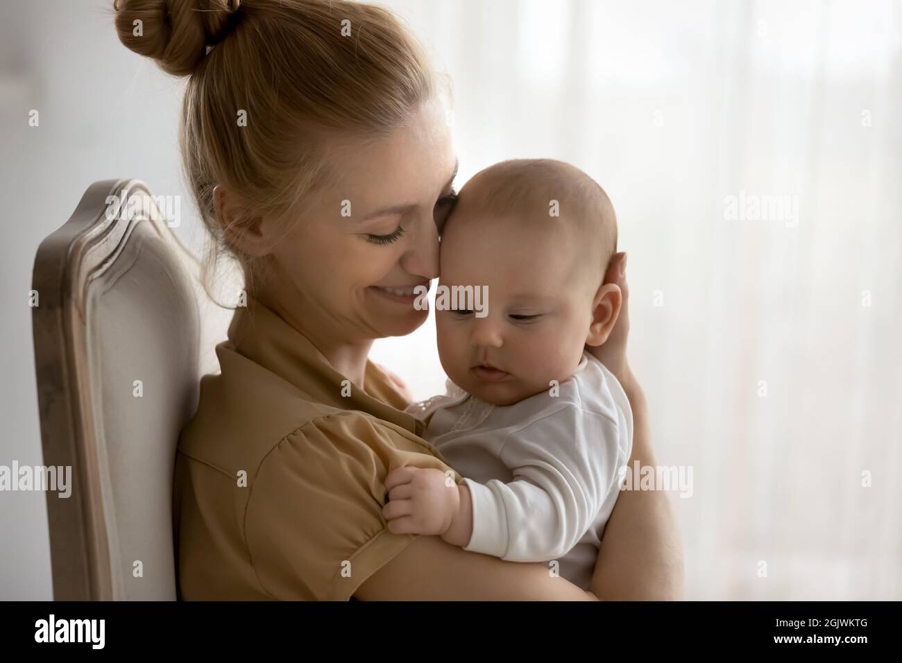 Happy peaceful mom hugging and kissing adorable baby Stock Photo - Alamy