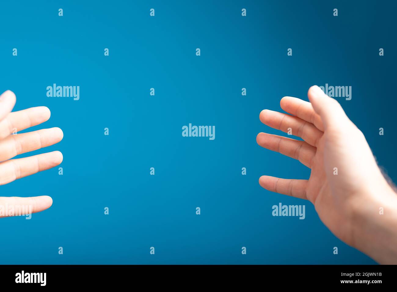 Two outstretched hands with open palms on a blue background Stock Photo ...