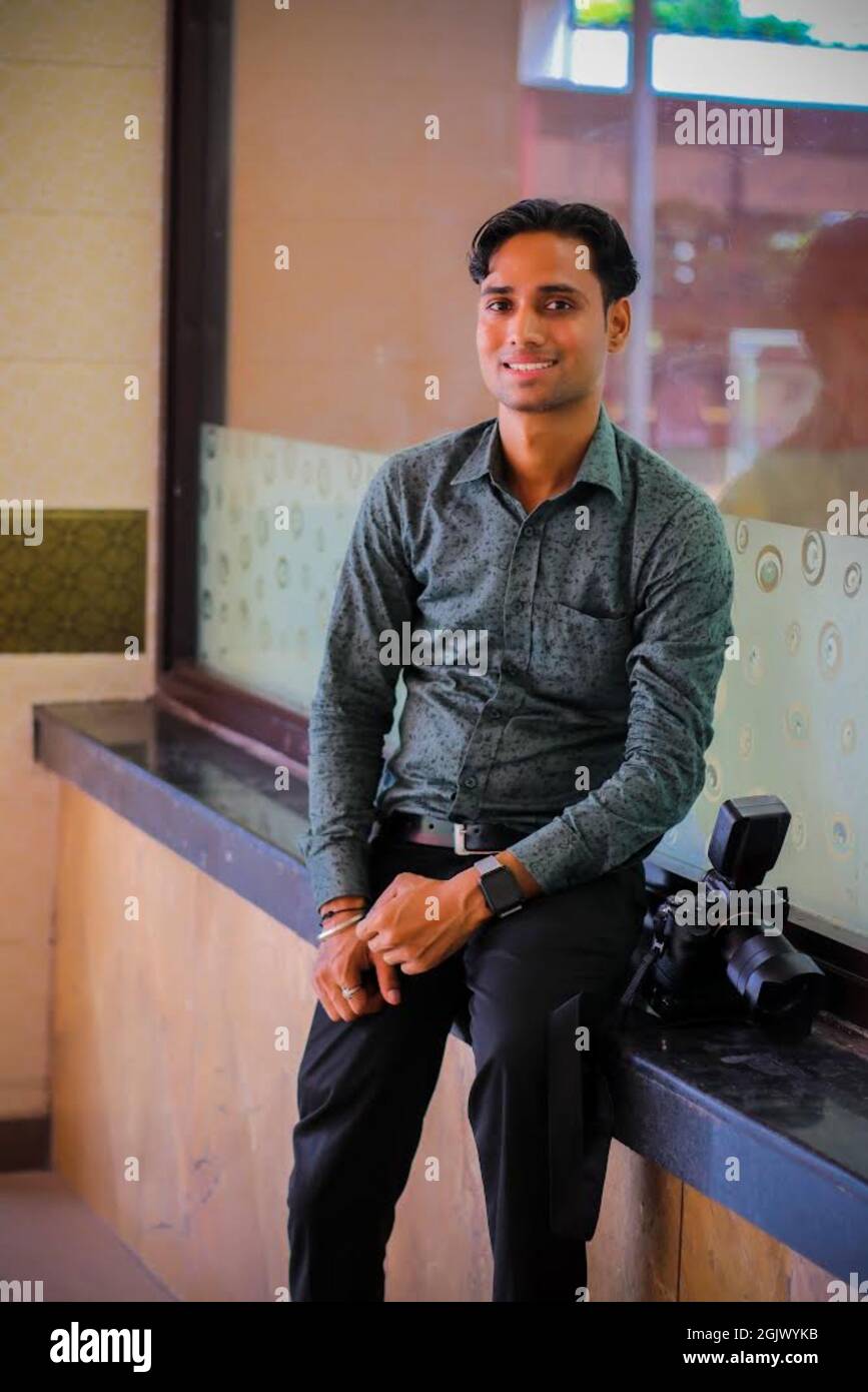 A vertical shot of a smiling handsome Indian male with a professional ...