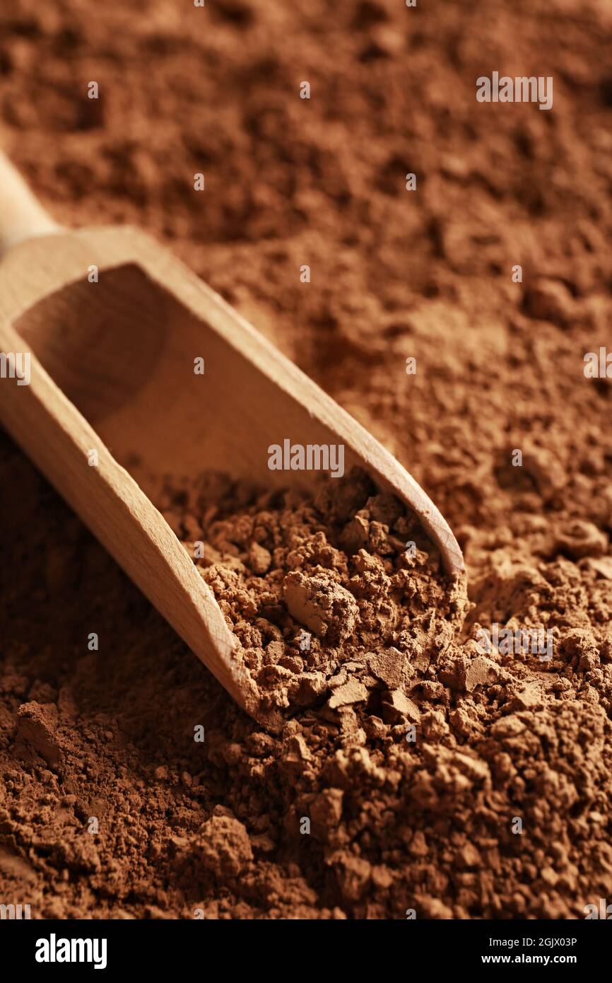 Wooden scoop on cocoa powder background Stock Photo - Alamy