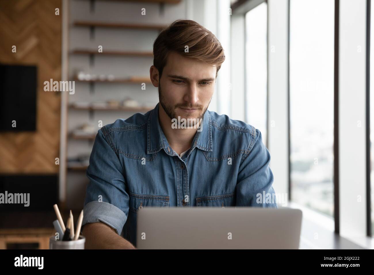 Serious male employee work on computer texting Stock Photo - Alamy