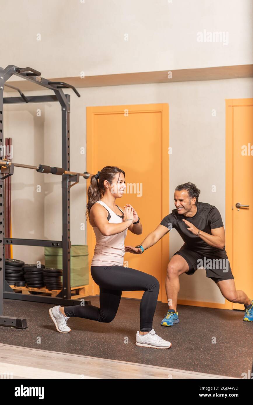 Young woman doing squats without weighting exercise in gym Stock Photo ...