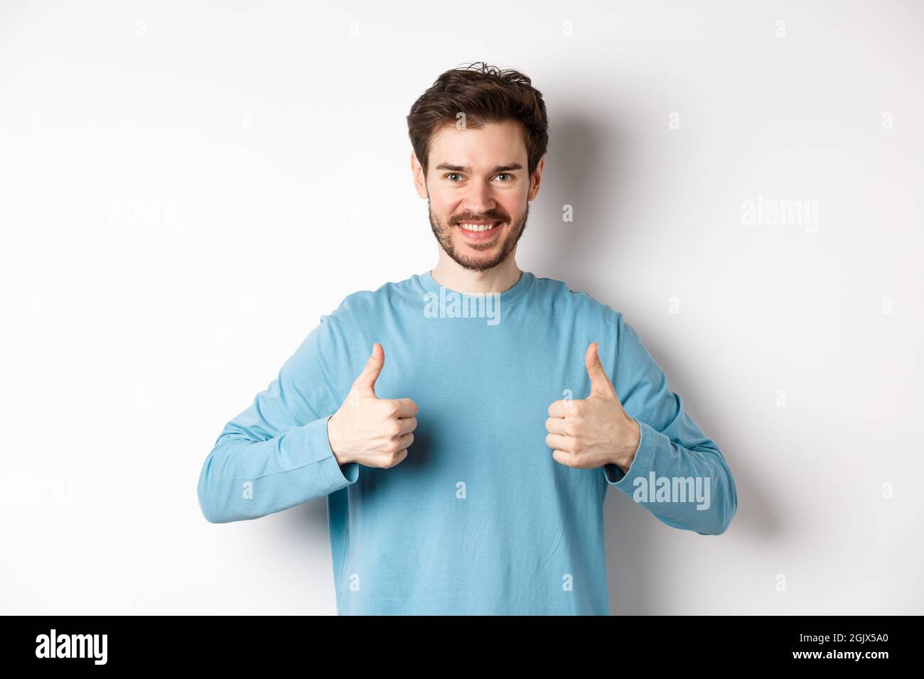 Smiling handsome man showing thumbs up, like and approve good choice ...