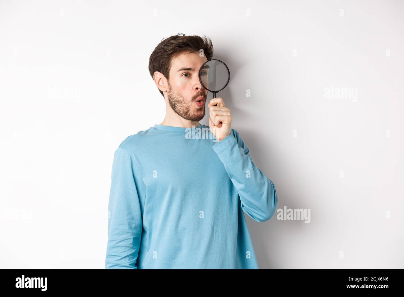 Curious guy looking through magnifying glass on right logo, saying wow ...