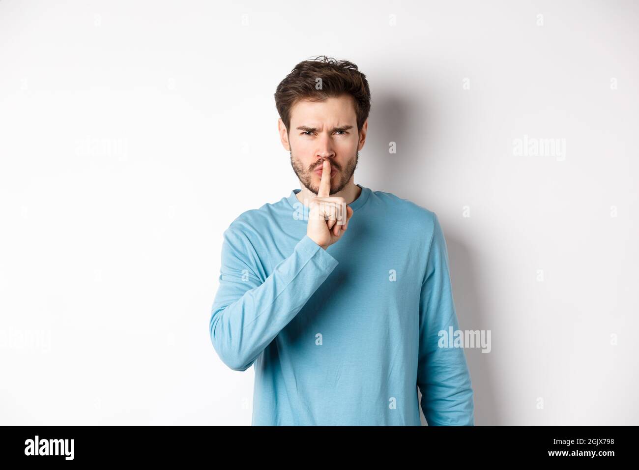 Angry man shushing at camera and telling to be quiet, frowning upset ...