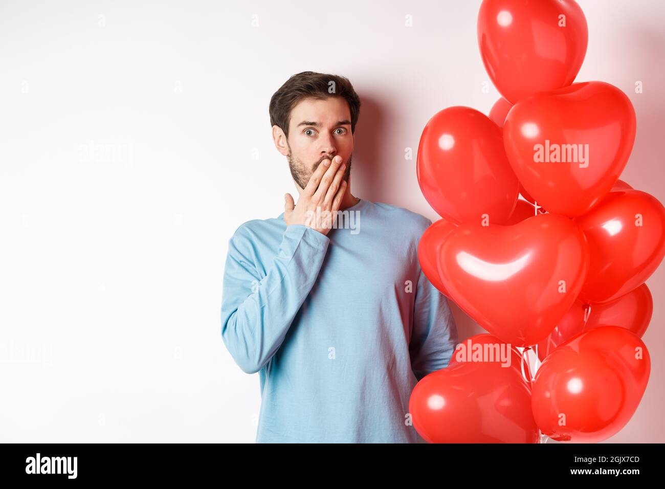 Portrait of man boyfriend standing near Valentines day heart balloons ...