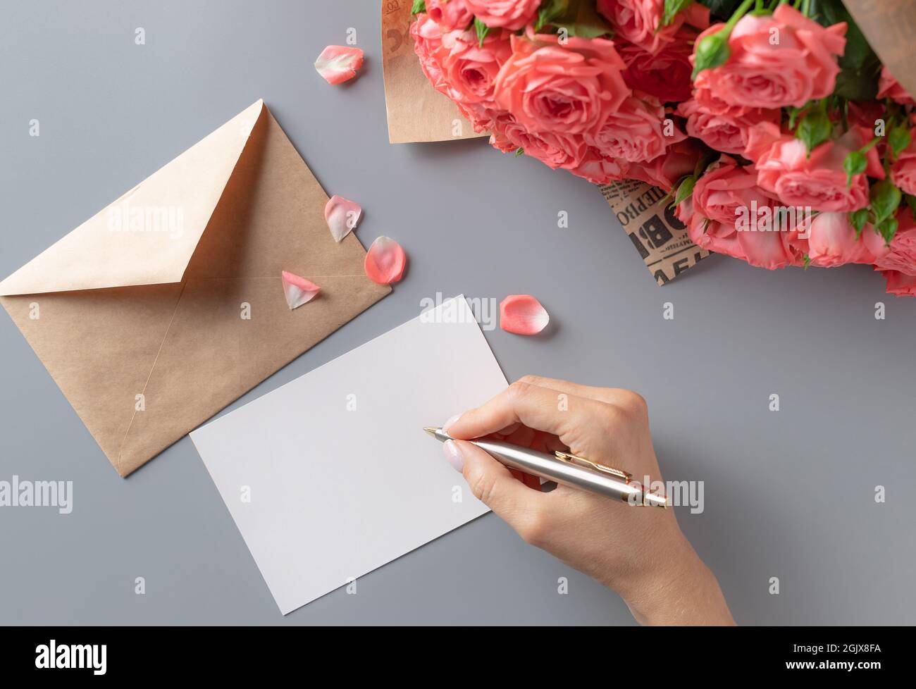 woman writing greeting card on gray table with roses Stock Photo - Alamy