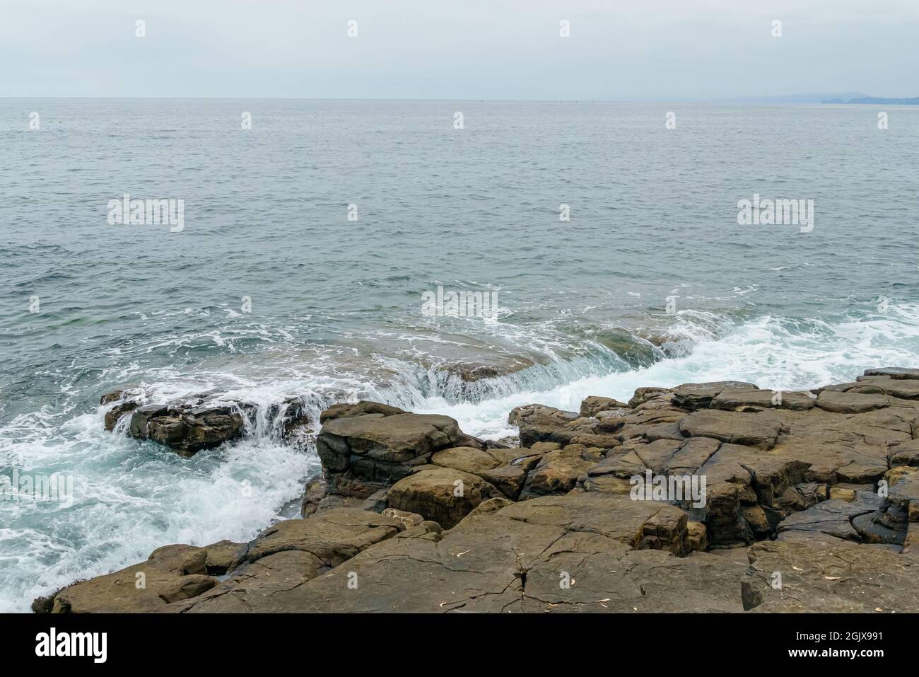 Waves hitting on the rock Stock Photo - Alamy