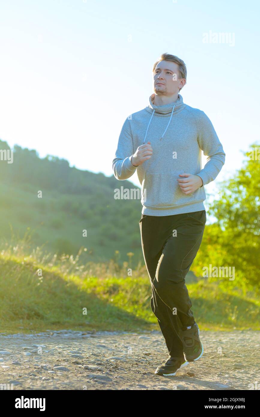 Running man jogging in rural nature at beautiful summer day. Sport ...