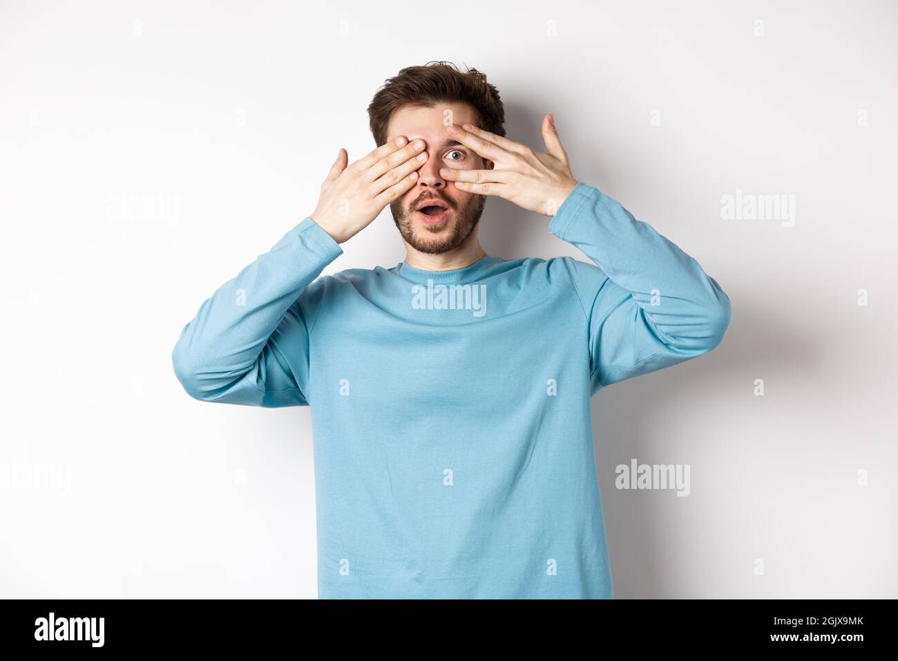 Hands peeking through fingers hi-res stock photography and images - Alamy