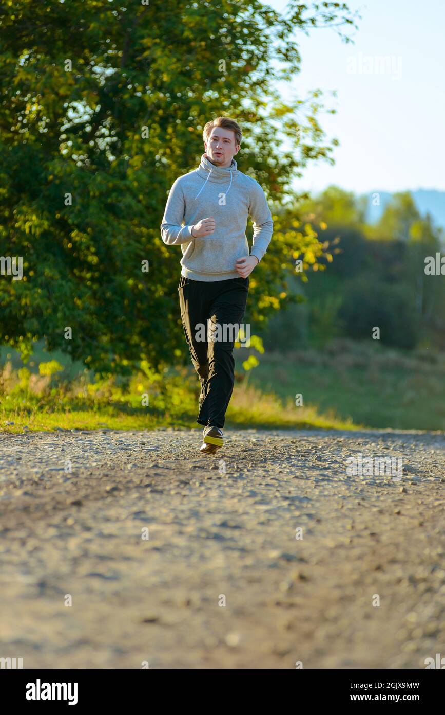 Running man jogging in rural nature at beautiful summer day. Sport ...