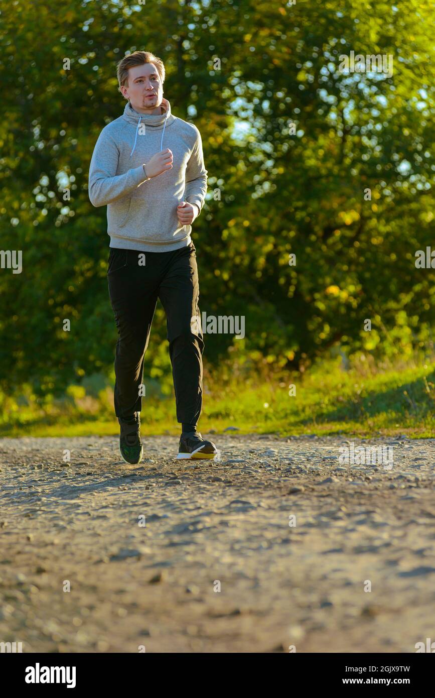 Running man jogging in rural nature at beautiful summer day. Sport ...