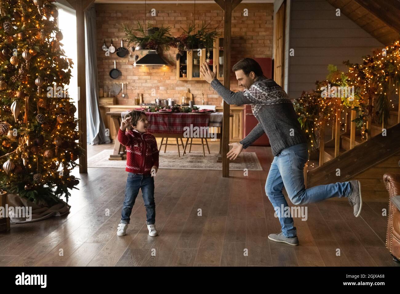 Happy father dancing with small son in decorated living room Stock ...