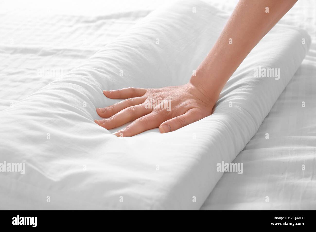 Female hand touching white orthopedic pillow. Healthy posture concept ...
