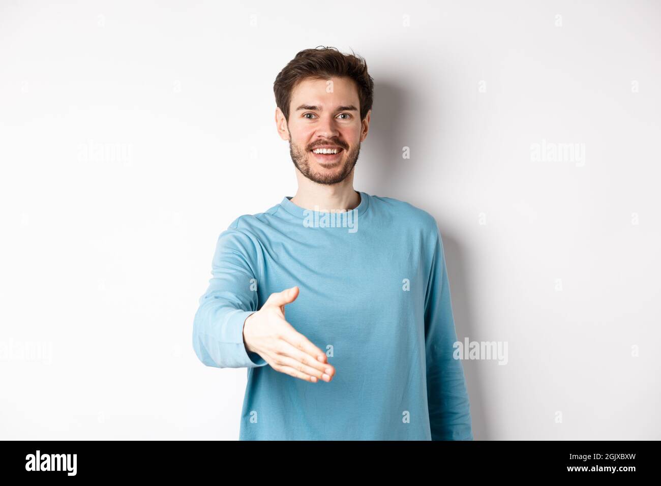 Friendly smiling man stretch out hand, saying hello and give arm for ...