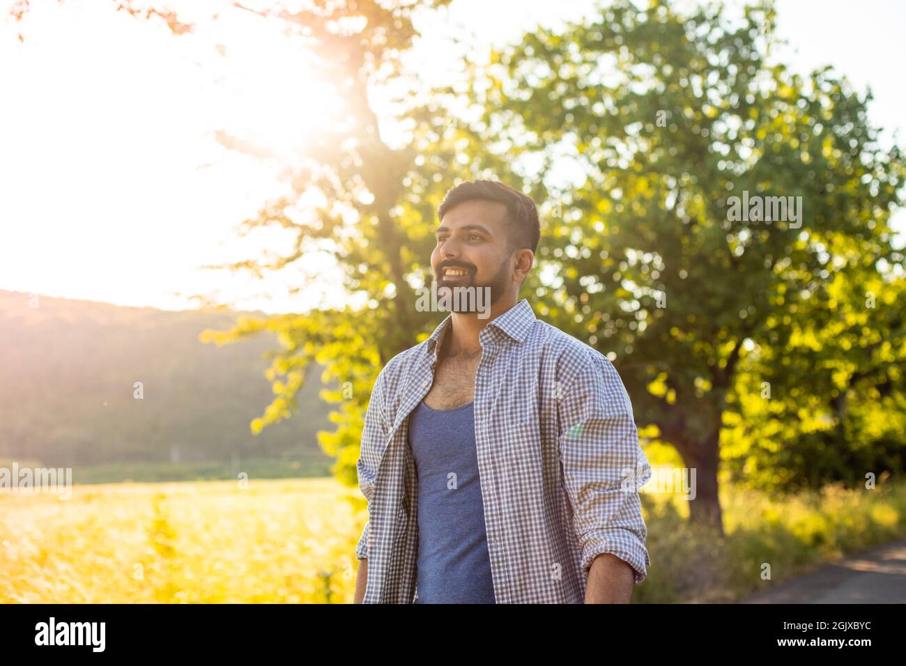 The young joyful man walks on a country road Stock Photo - Alamy
