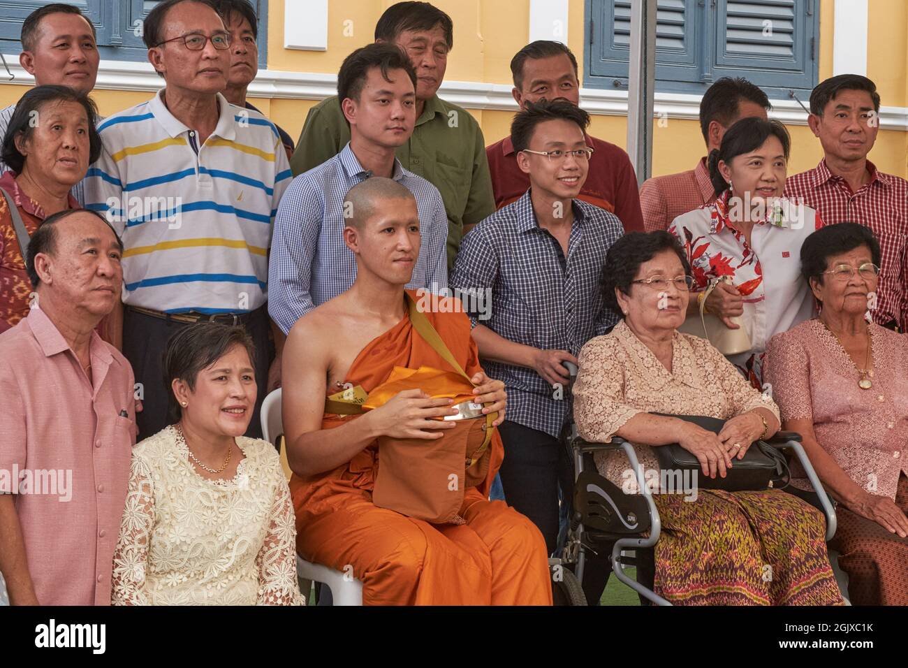 After the ordination of a young man as a Buddhist monk he poses with ...