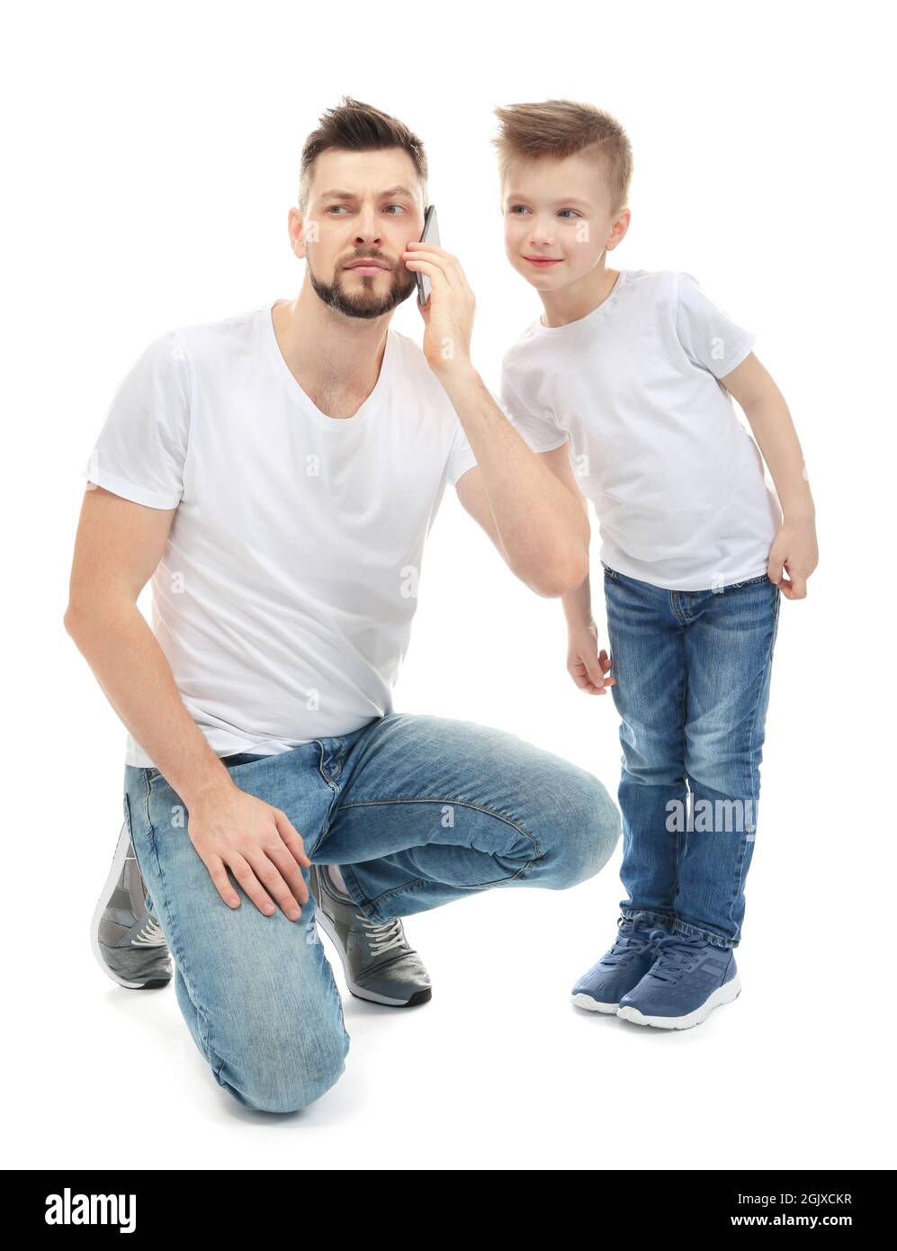 Little boy and his father talking by mobile phone, on white background ...