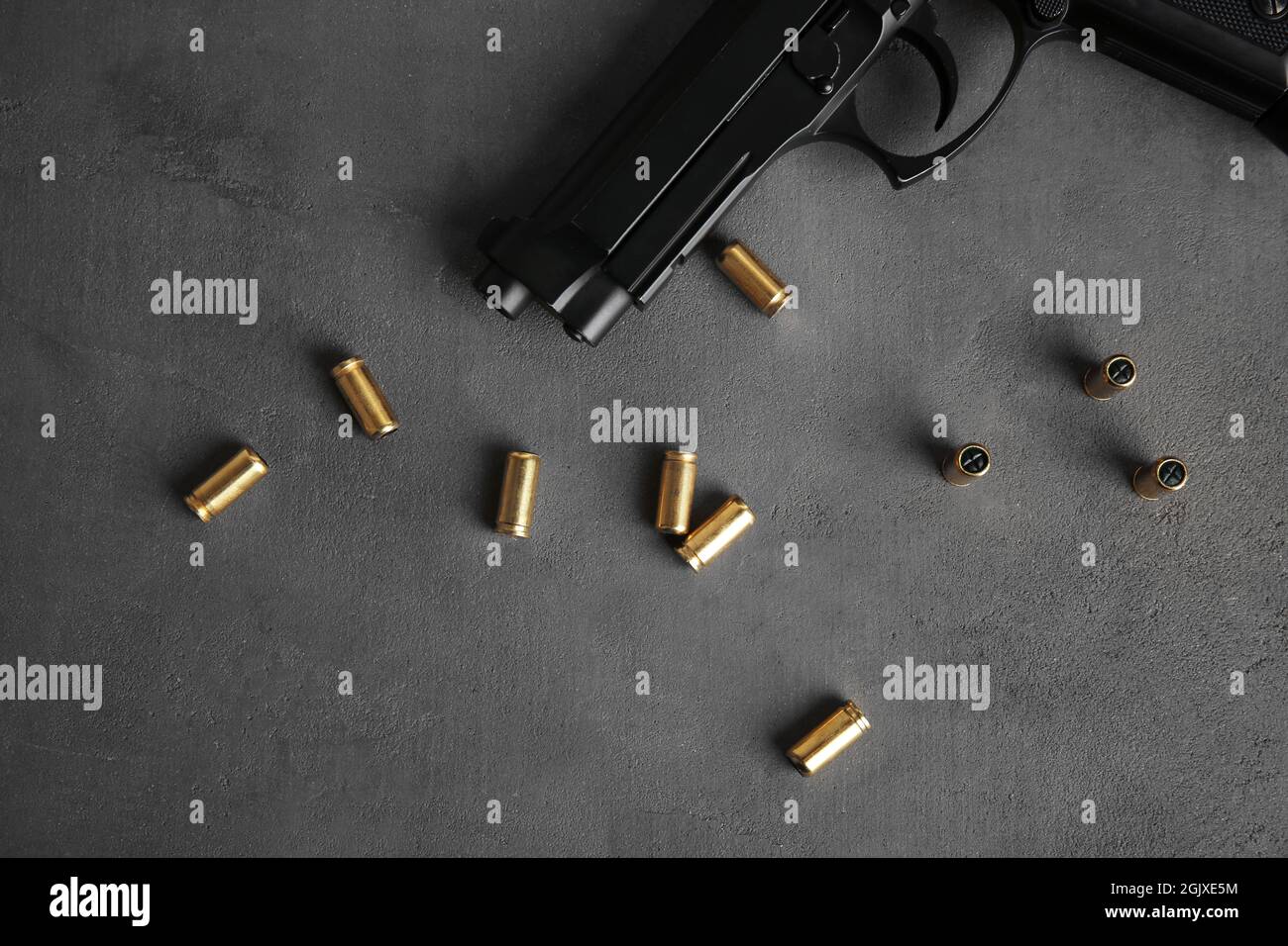 Bullets and gun on gray table Stock Photo - Alamy