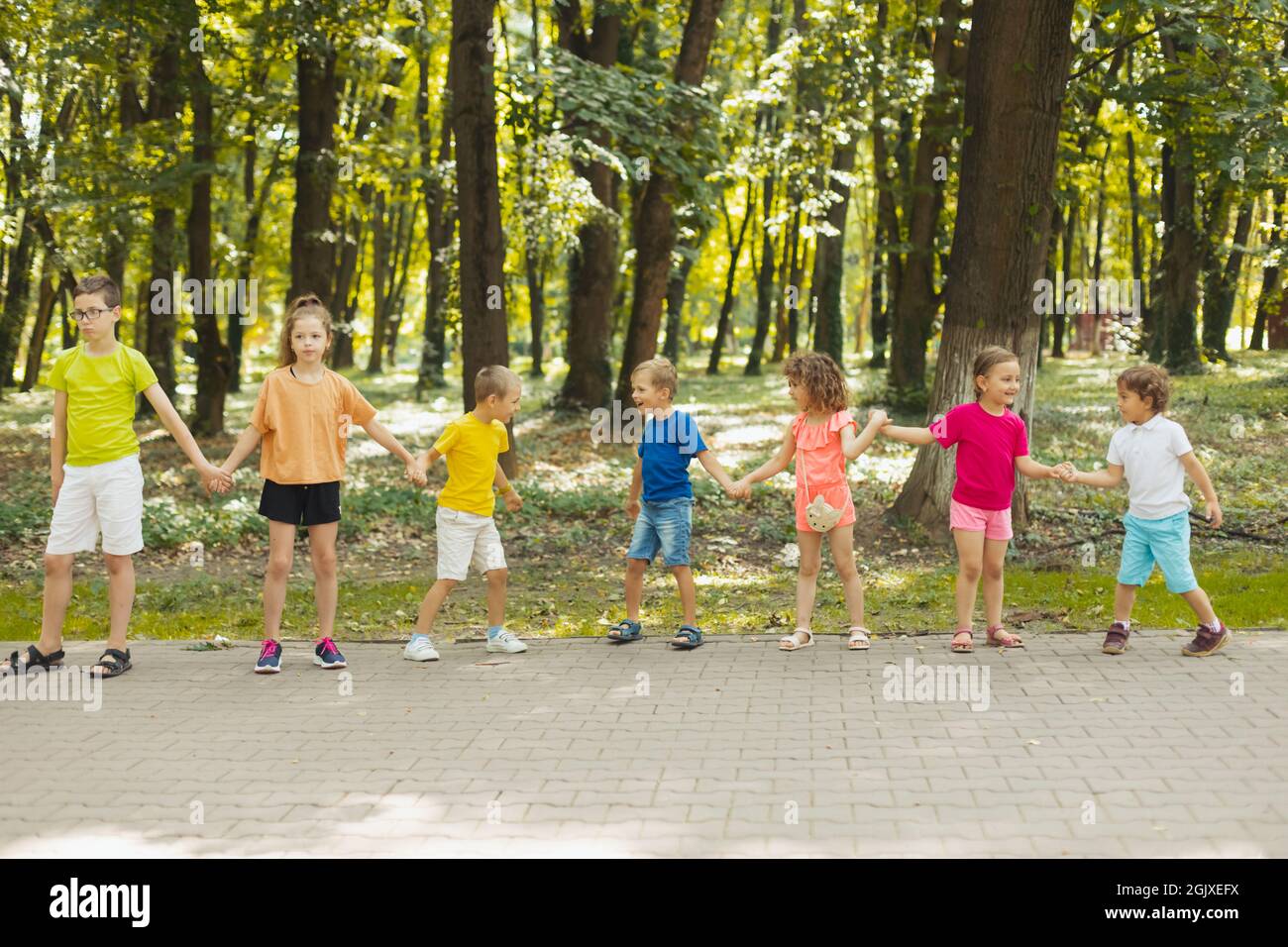 Summer camp kids making wave, holding hands together Stock Photo - Alamy