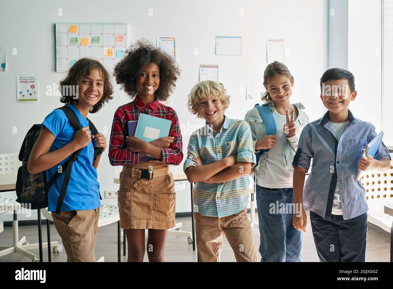 Portrait of happy cheerful smiling diverse schoolchildren in classroom ...