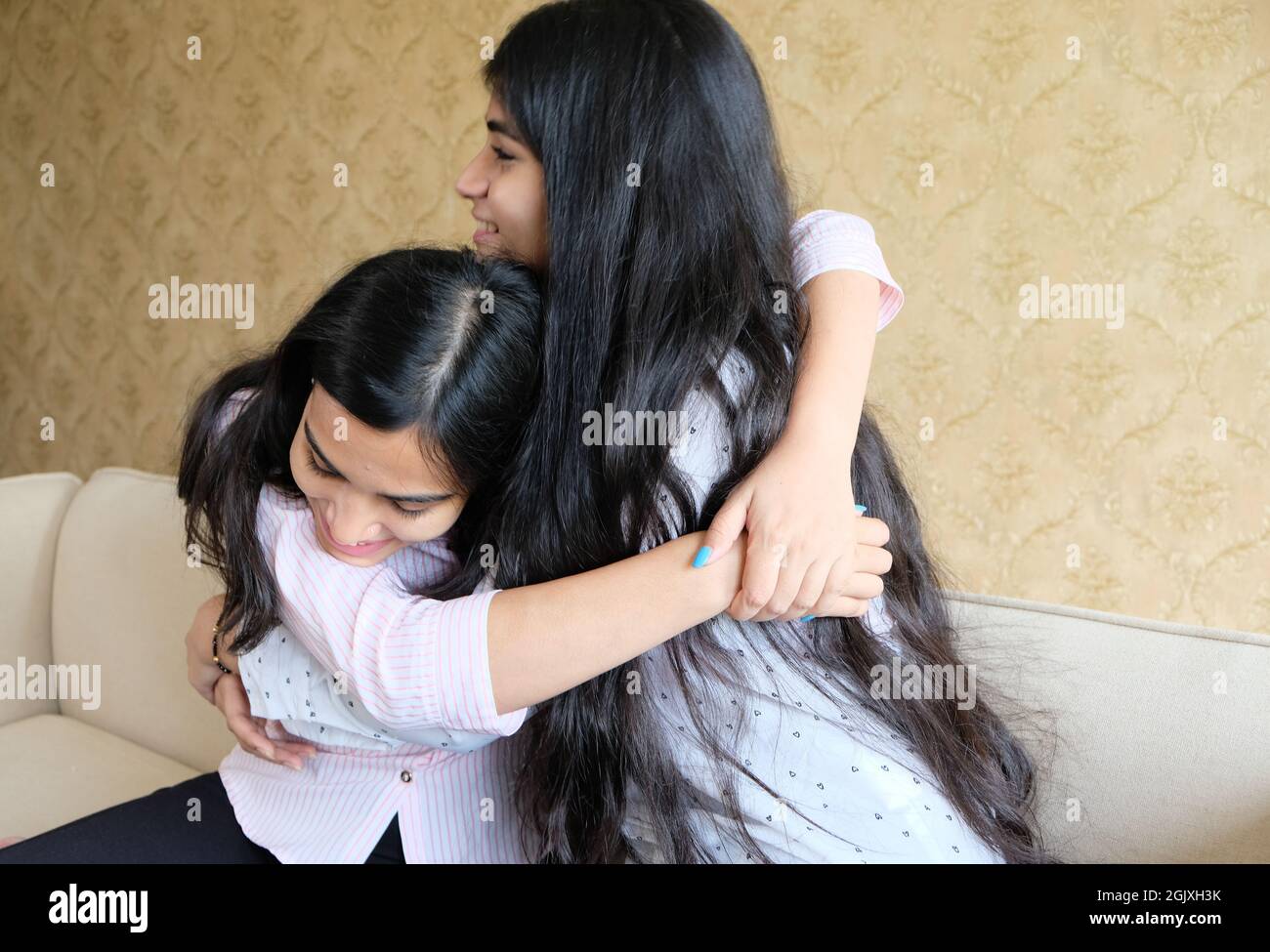 Two Indian friends happily hugging each other after discussing an ...