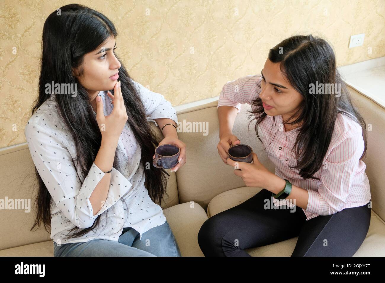 Two Indian best friends drinking coffee and talking about life while ...