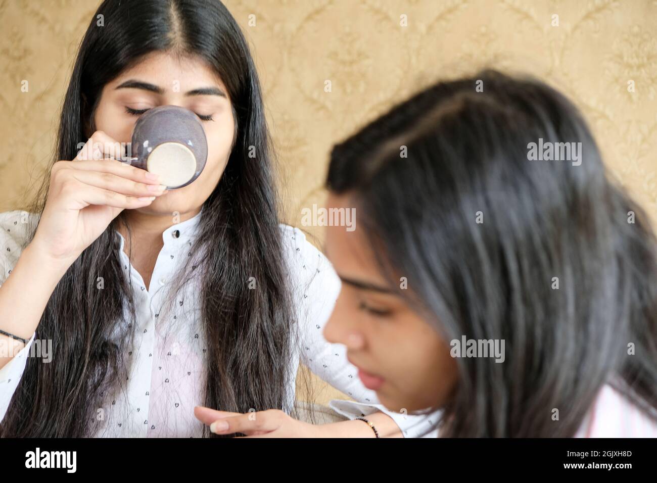Two Indian best friends drinking coffee and talking about life while ...