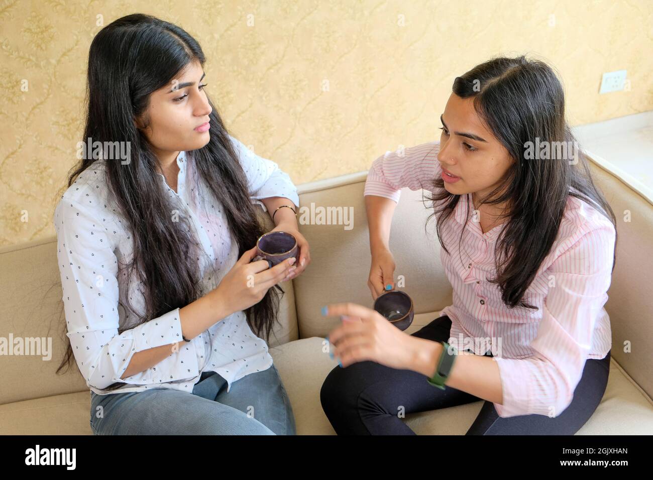 Two Indian best friends drinking coffee and talking about life while ...