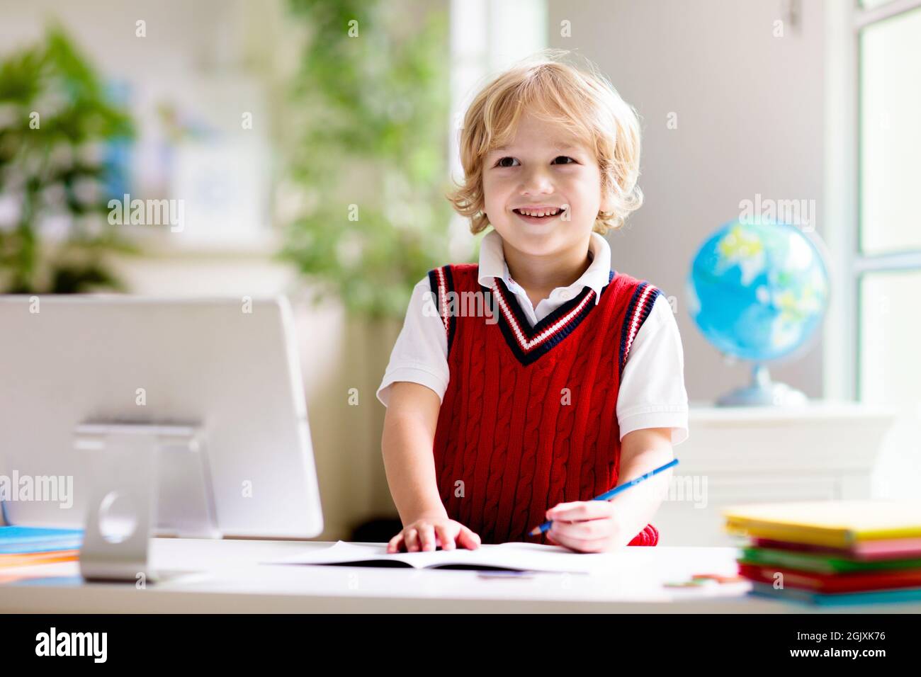 Online remote learning. School kids with computer having video conference chat with teacher and ...