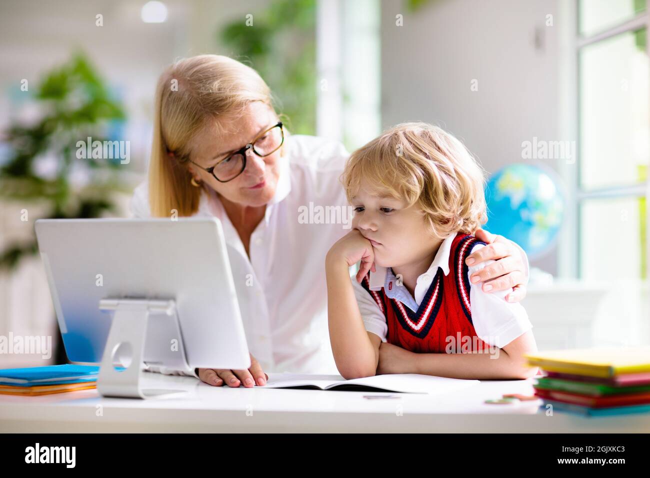Online remote learning. School kids with computer having video ...