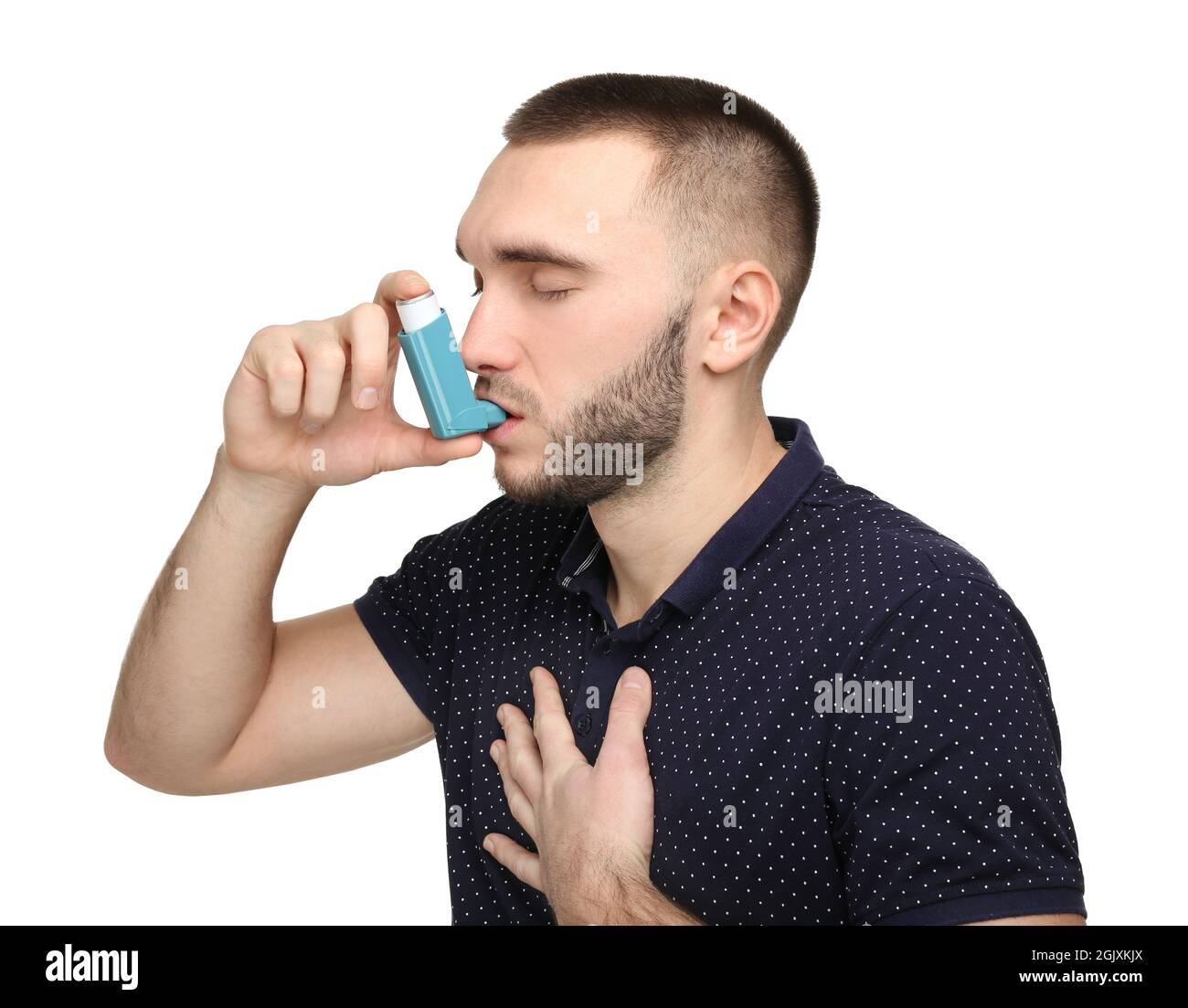 Young man using asthma inhaler on white background Stock Photo - Alamy