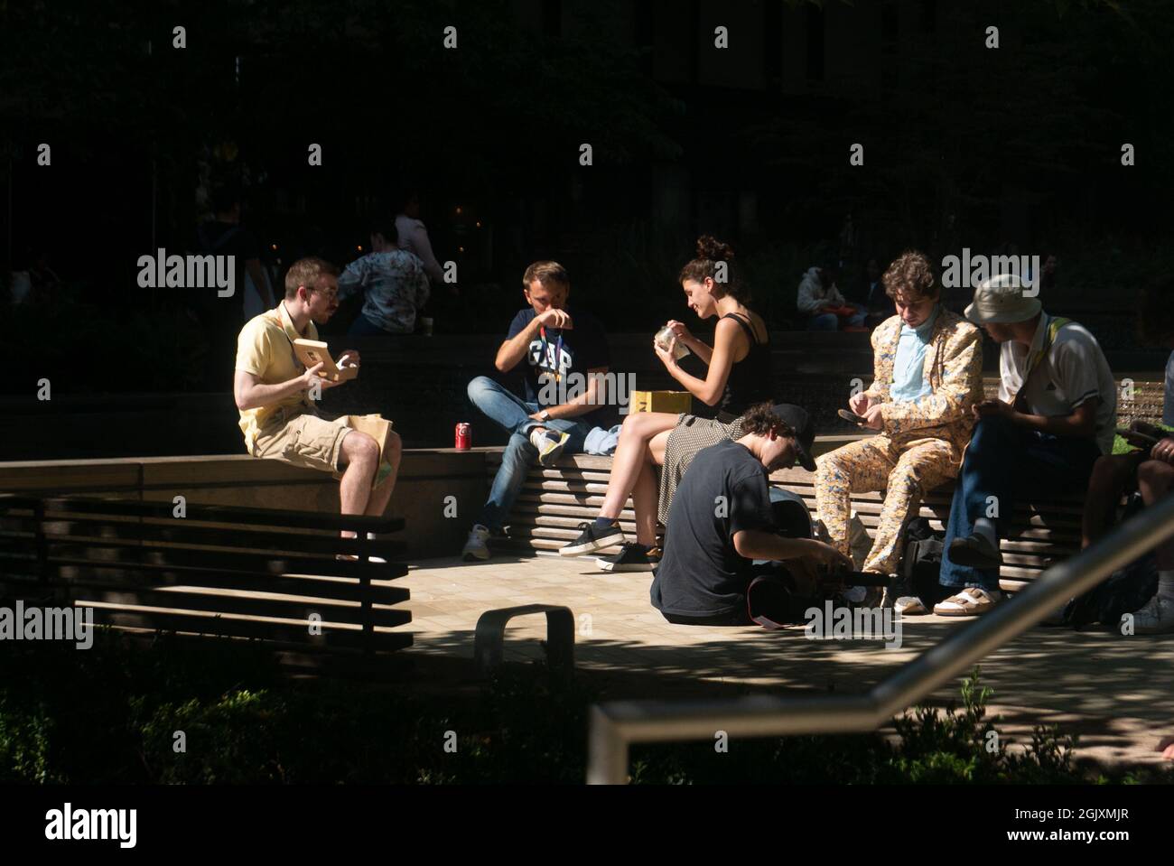 Office workers eat lunch in public park space outside offices in the ...