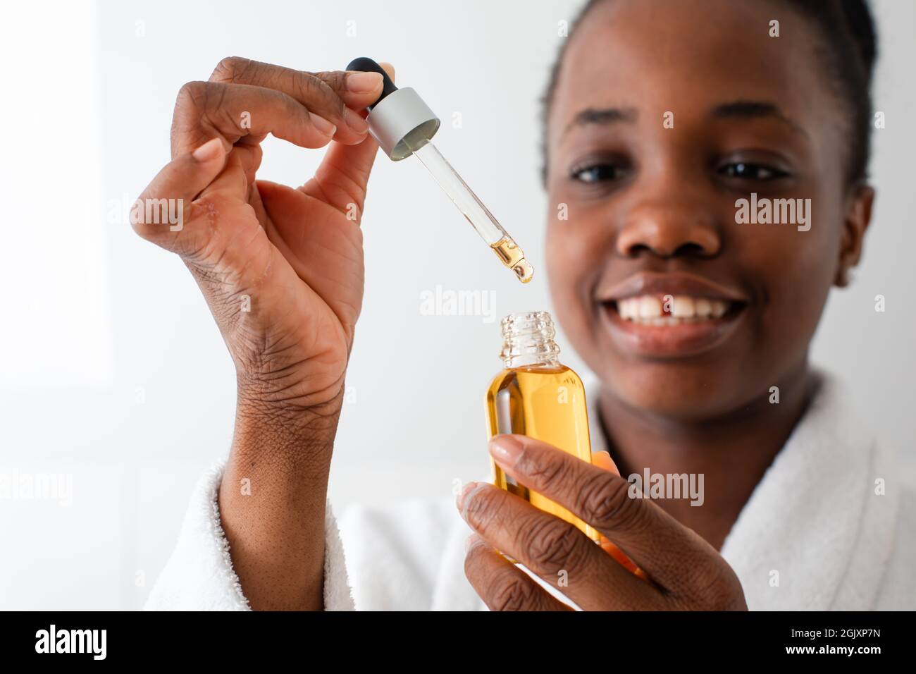 Bottle of serum with drop falling from pipette Stock Photo - Alamy