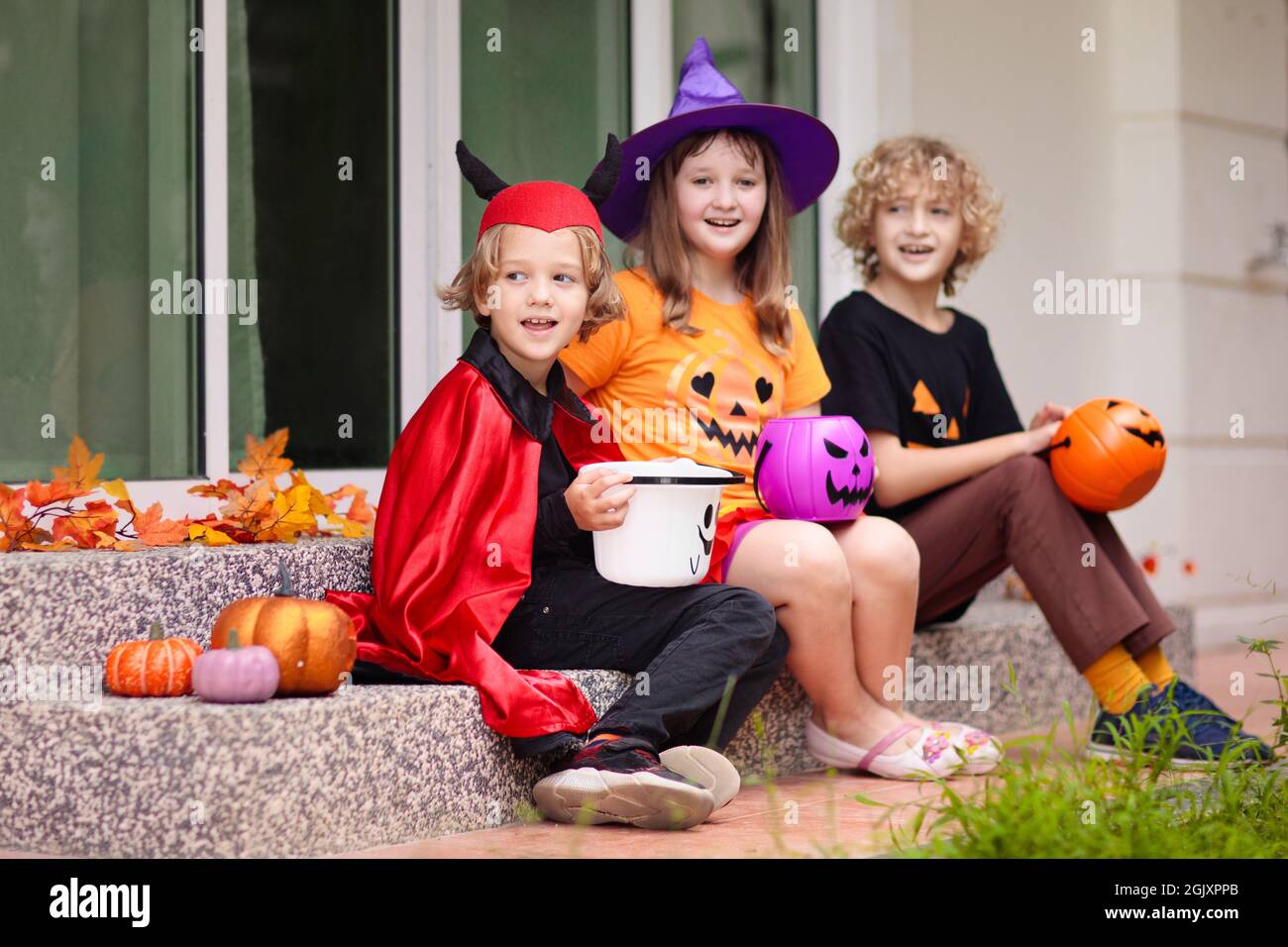 Kids trick or treat on Halloween night. Child at decorated house door ...