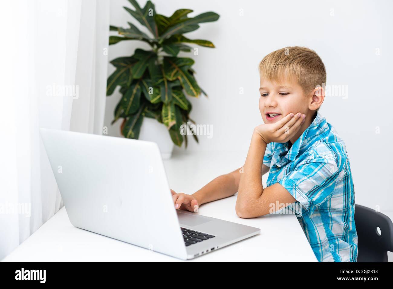 Closeup view of little kid talking with family via video chat at home ...