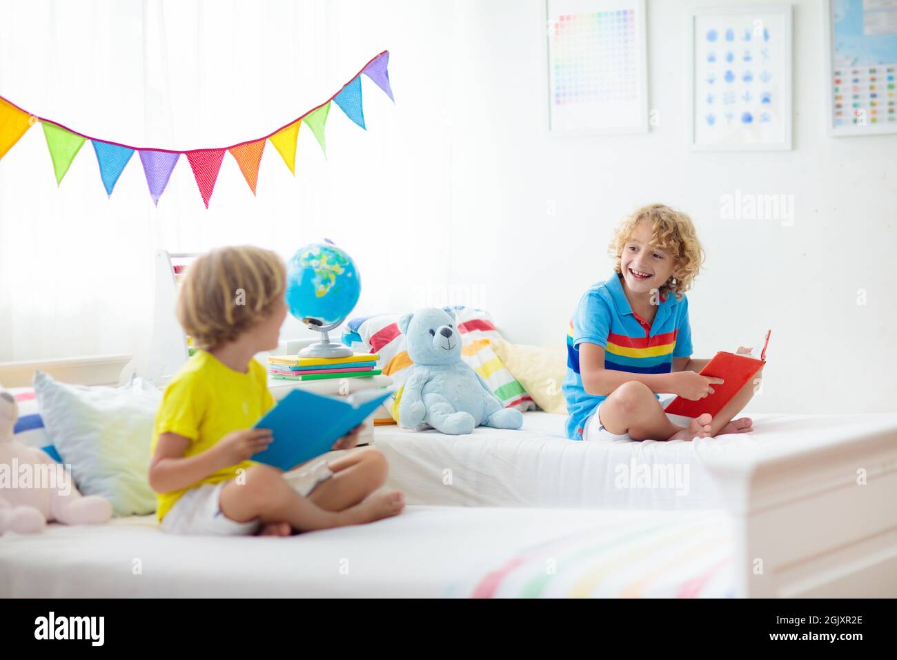 Child reading book in bed. Bedroom for two kids. Little boys read books ...
