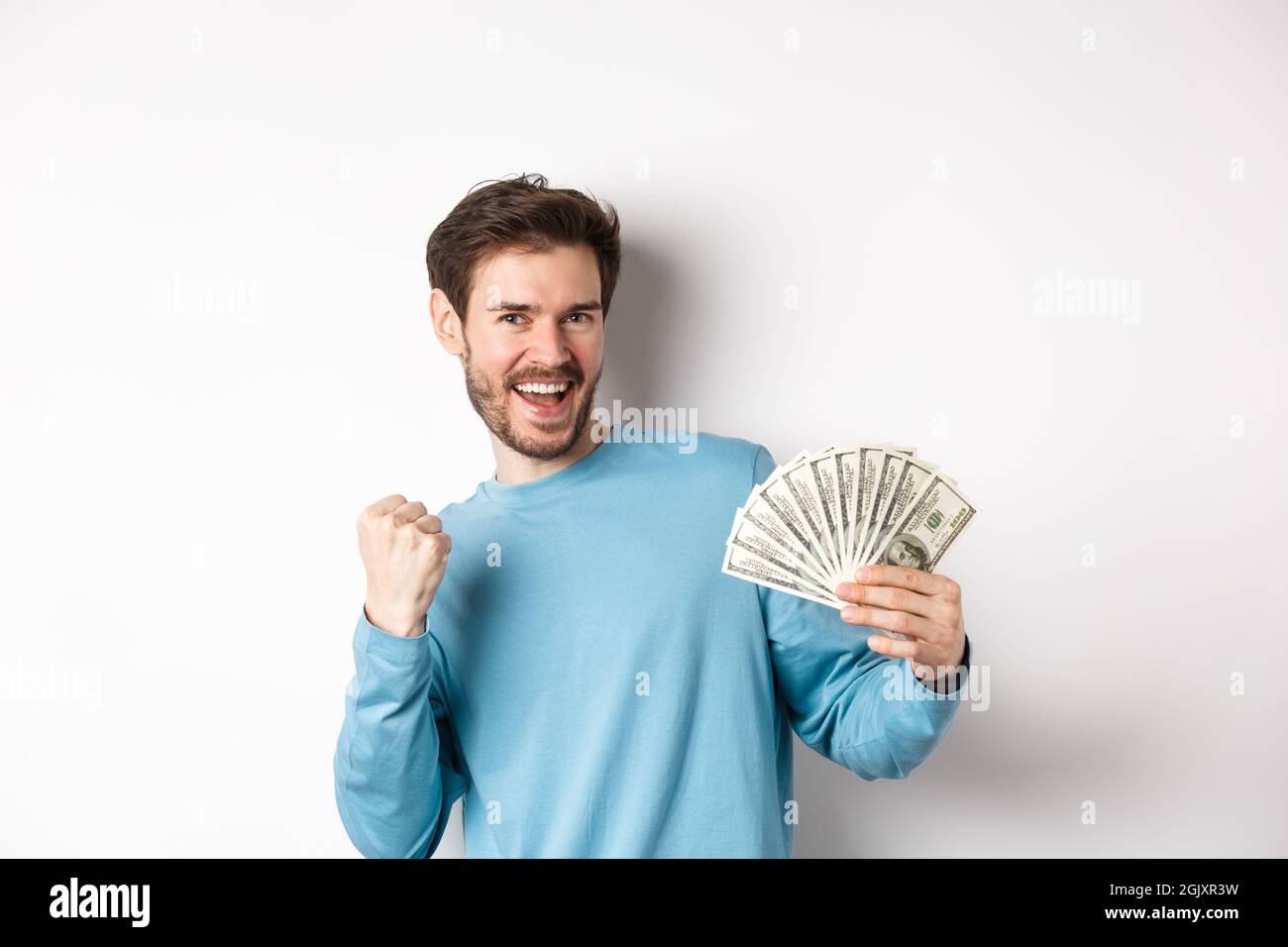 Happy man dancing with money, showing dollars and saying yes with ...