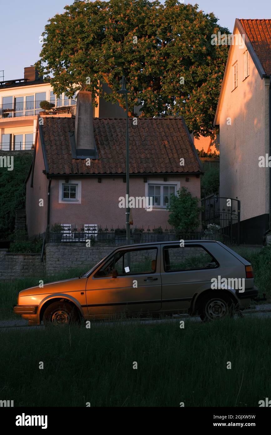 A vertical shot of a car parked in front of a small building in the ...