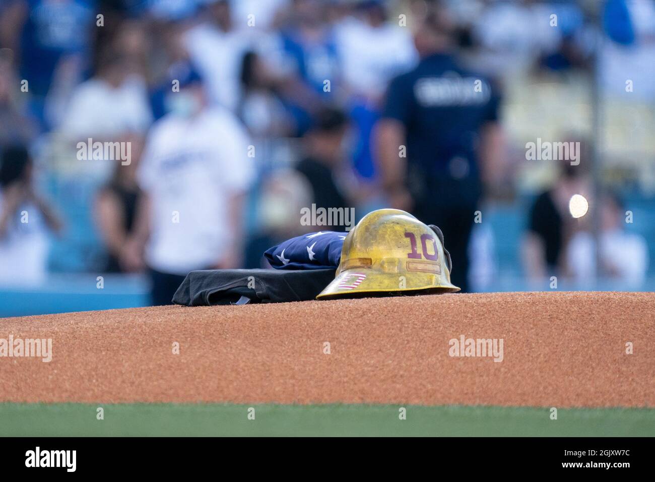 A fireman’s helmet and an American flag placed on the pitchers mound to ...