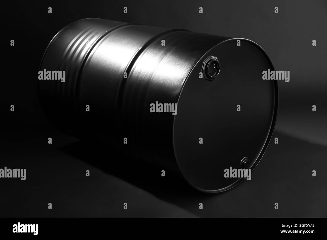 Black oil barrel on dark background Stock Photo - Alamy