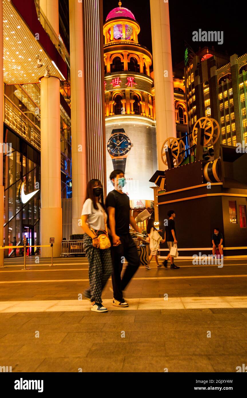 A young couple walking under the Shimao building on Nanjing East Road ...