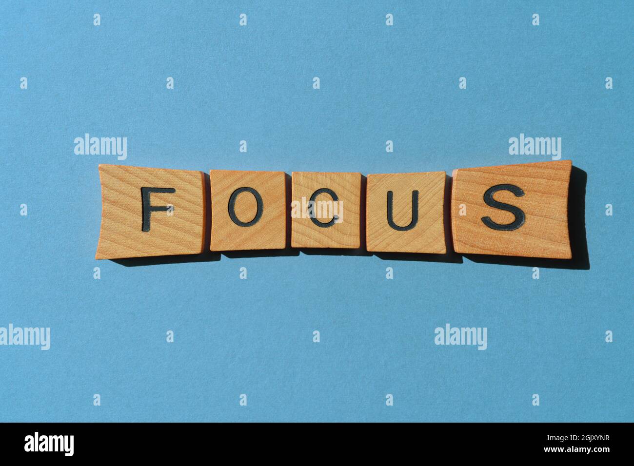 Focus, word in wooden alphabet letters isolated on purple background ...