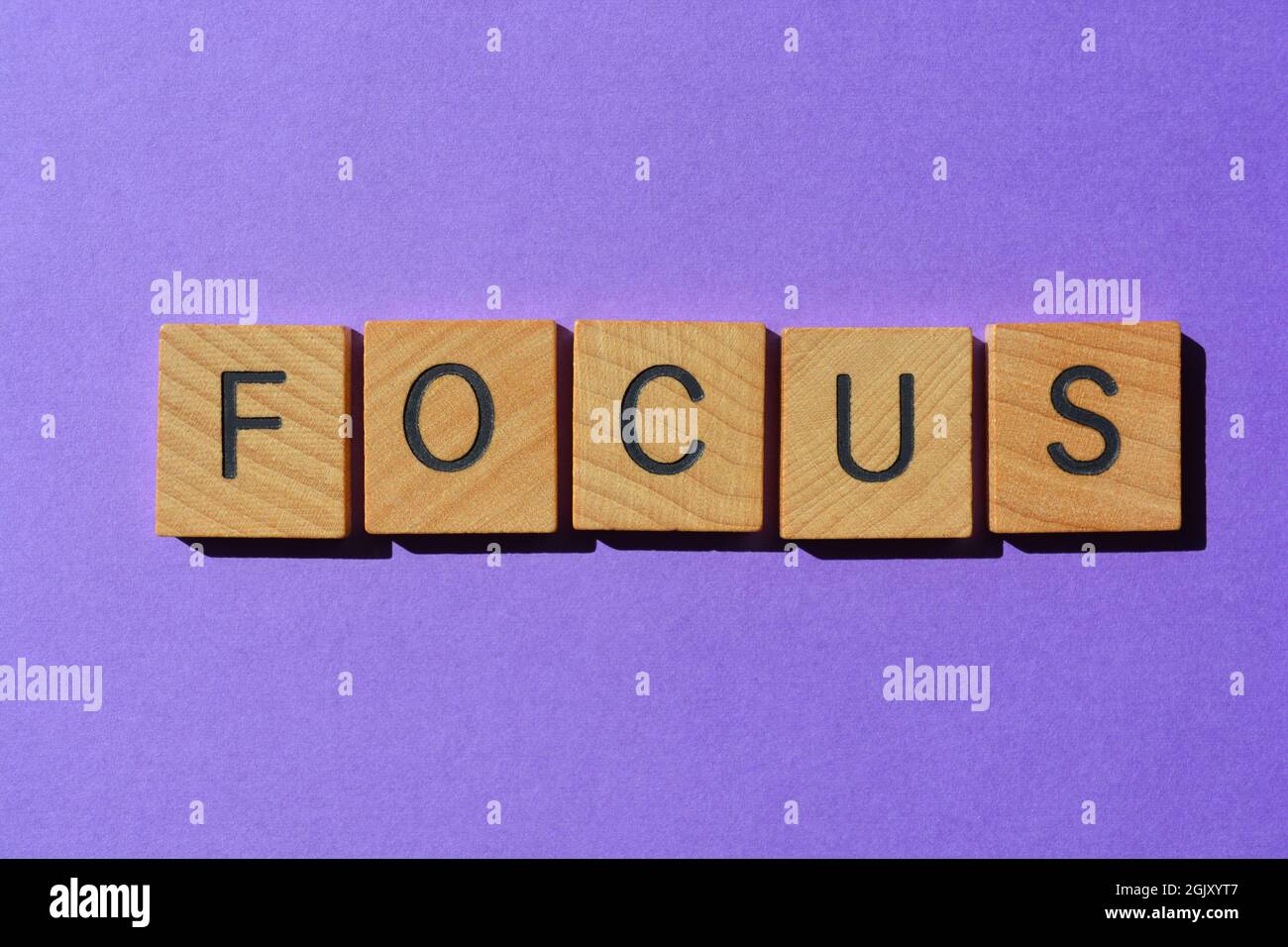 Focus, word in wooden alphabet letters isolated on purple background ...