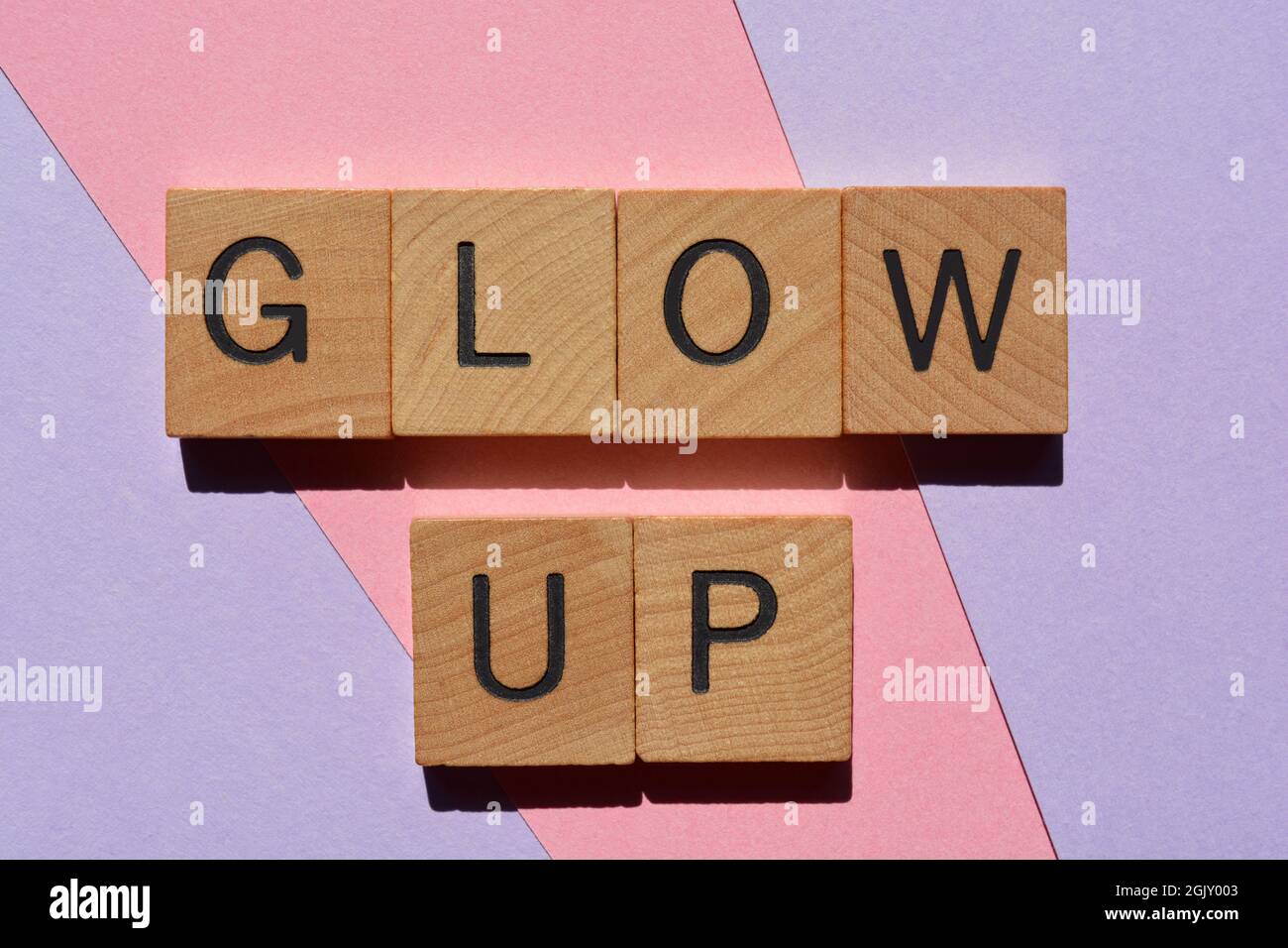 Glow Up, words in wooden alphabet letters isolated on pastel background ...