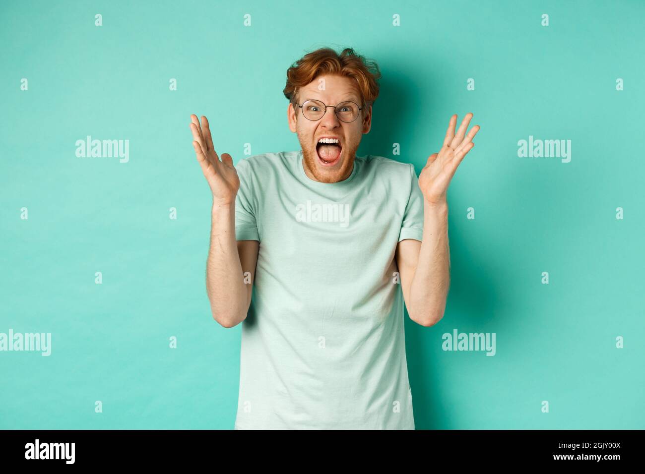 Portrait of distressed and angry redhead guy losing temper, shouting ...